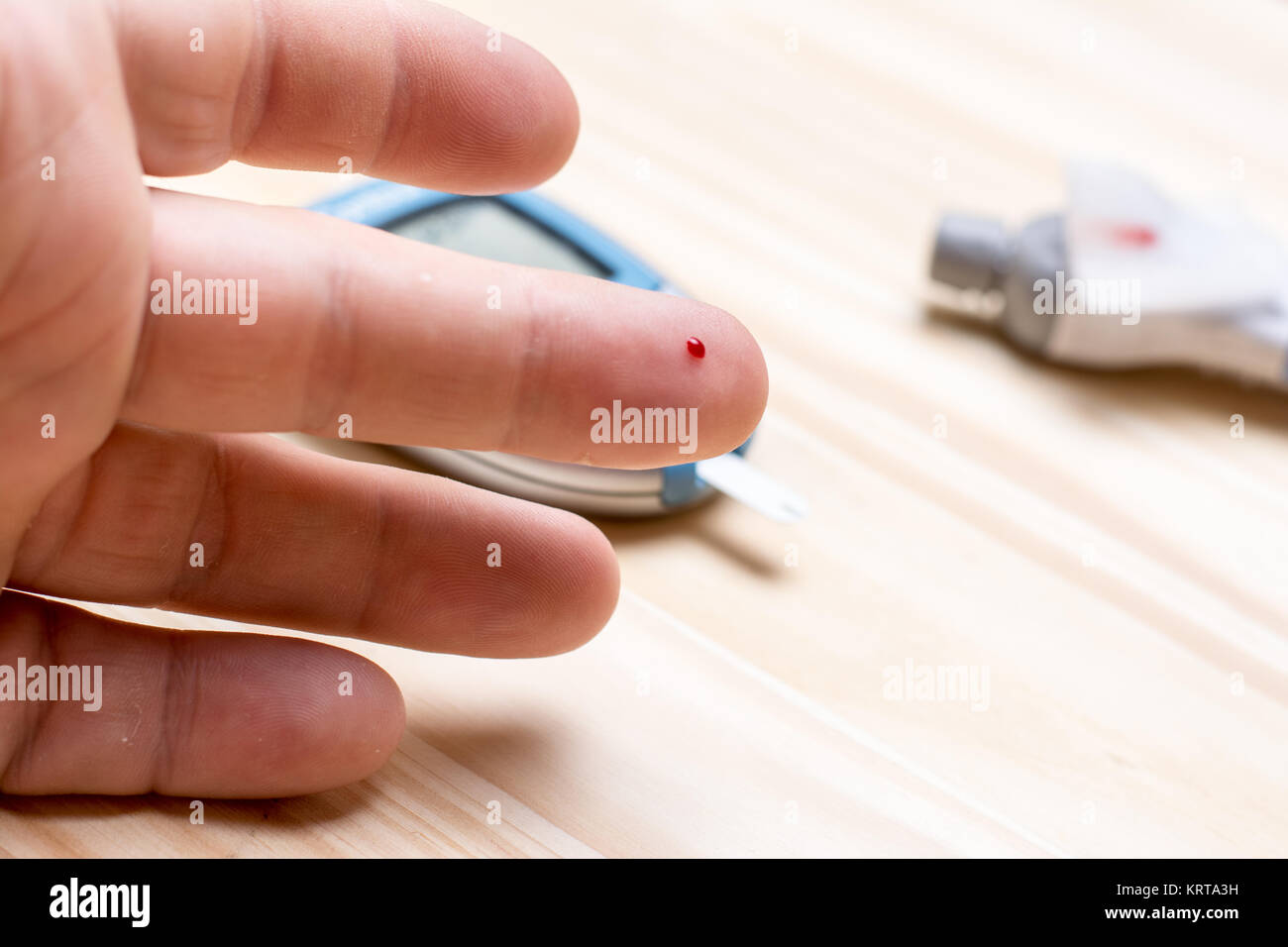 diabetic male hand testing blood sugar drop of blood on finger and ...