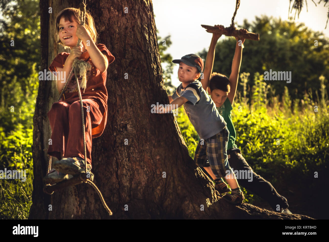 Cheerful children having fun outdoors in forest during summer holidays ...