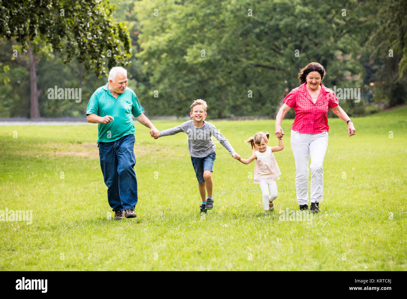 Grandparents And Grandchildren Running In Park Stock Photo - Alamy