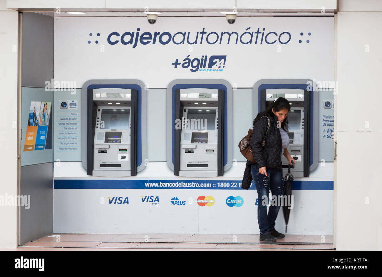 Ecuador ATM - a woman using a cash machine of Banco del Austro, an ...