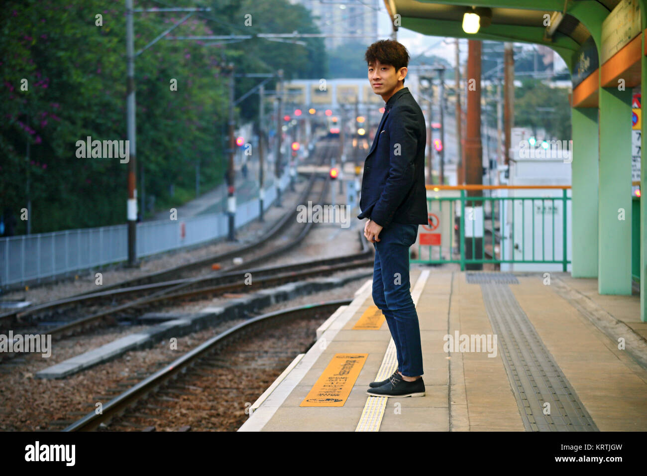 Asia man waiting train Stock Photo - Alamy
