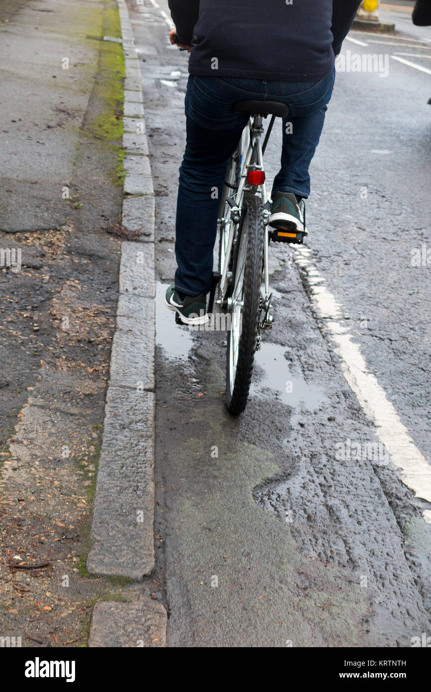 Cyclist riding & poor quality broken bicycle / bike / cycle lane ...