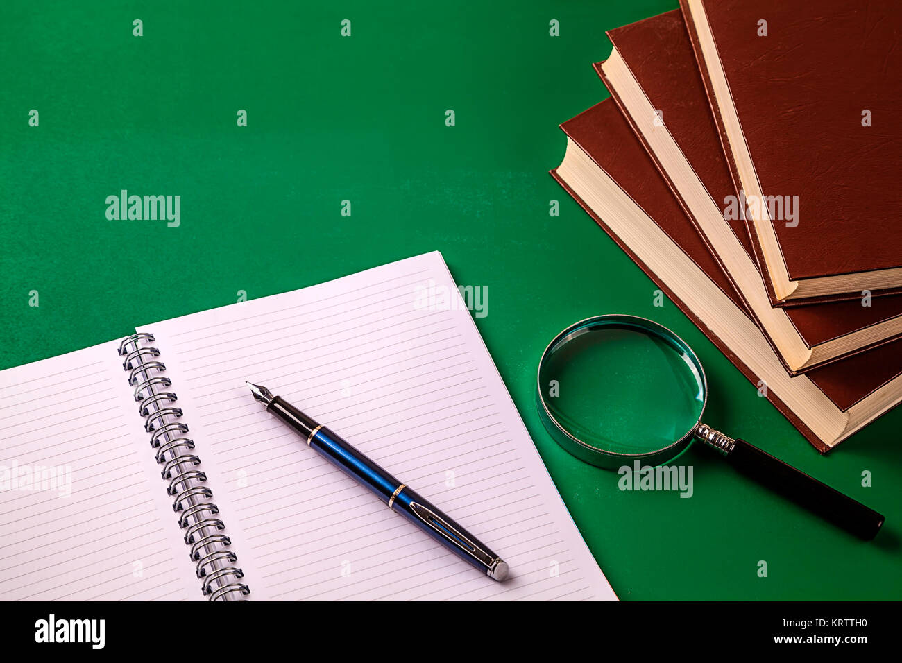 Notebook with magnifier glass and books Stock Photo - Alamy