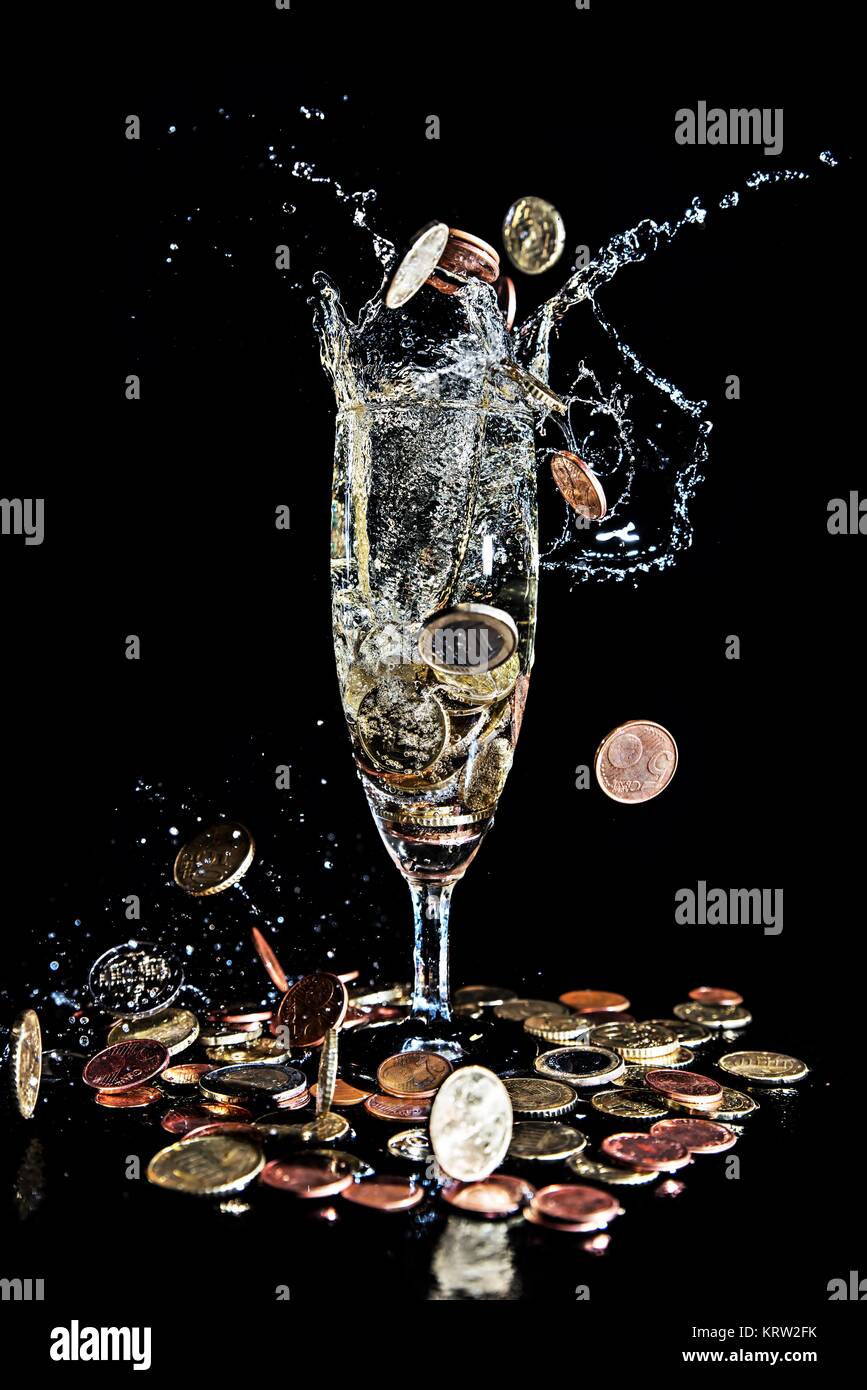Coins fall into a Glass of Sparkling wine Stock Photo - Alamy