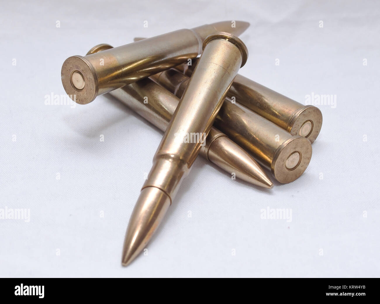 Several large caliber rifle bullets together on a white background ...