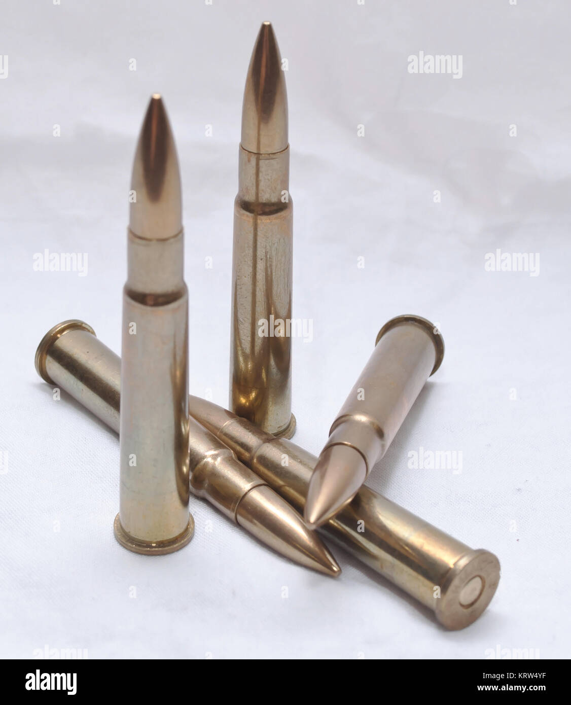 Several large caliber rifle bullets together on a white background ...