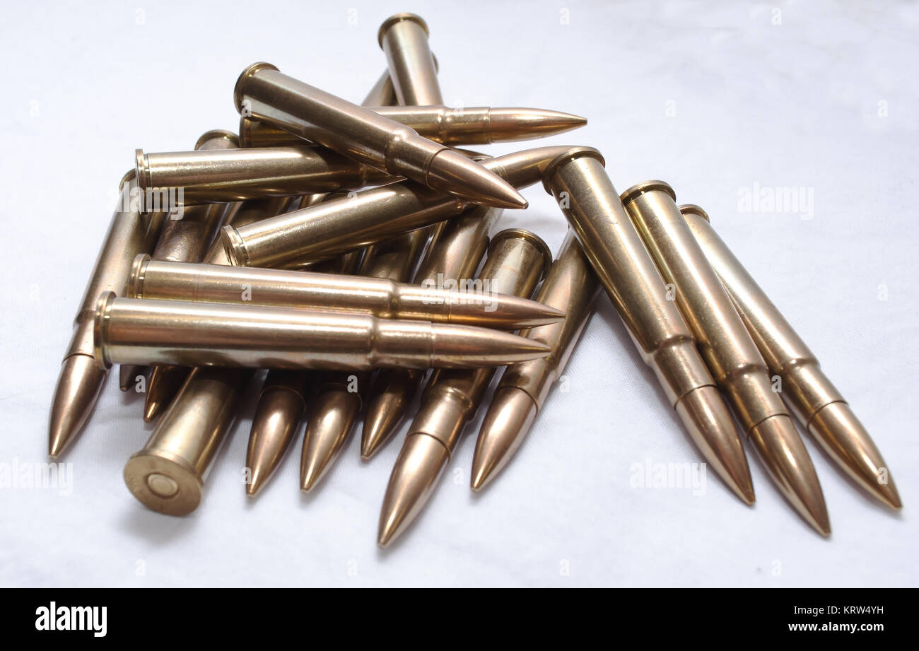 Several large caliber rifle bullets together on a white background ...