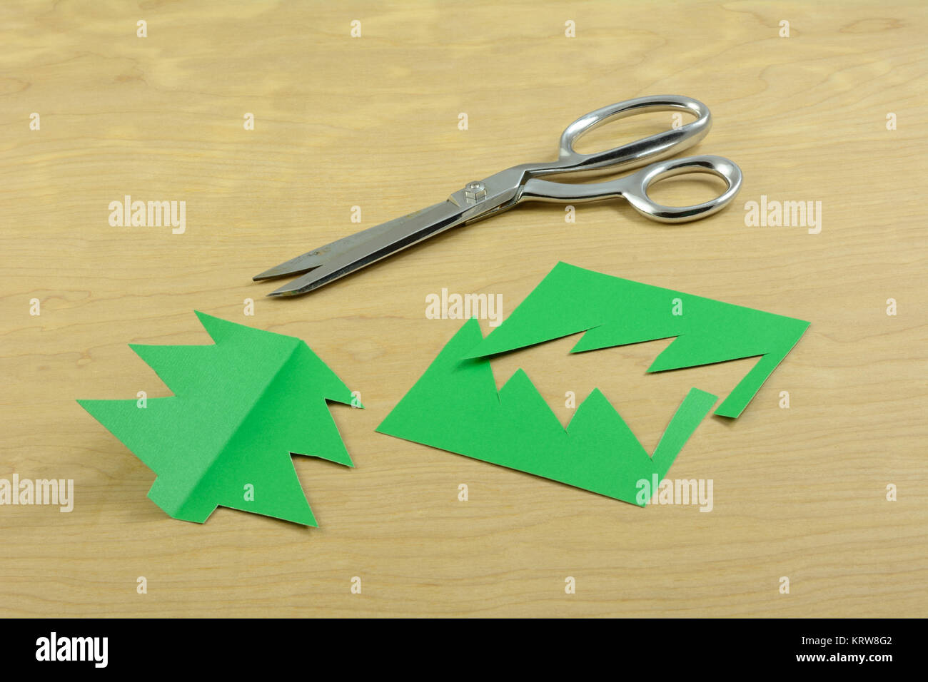 Stainless steel scissors and Christmas tree cut from construction paper ...