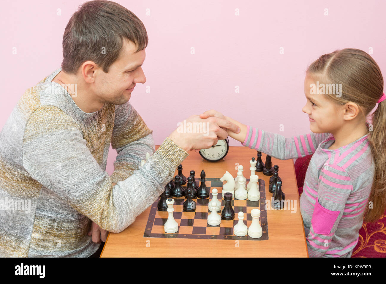 Dad and daughter shook hands, playing a game of chess Stock Photo - Alamy
