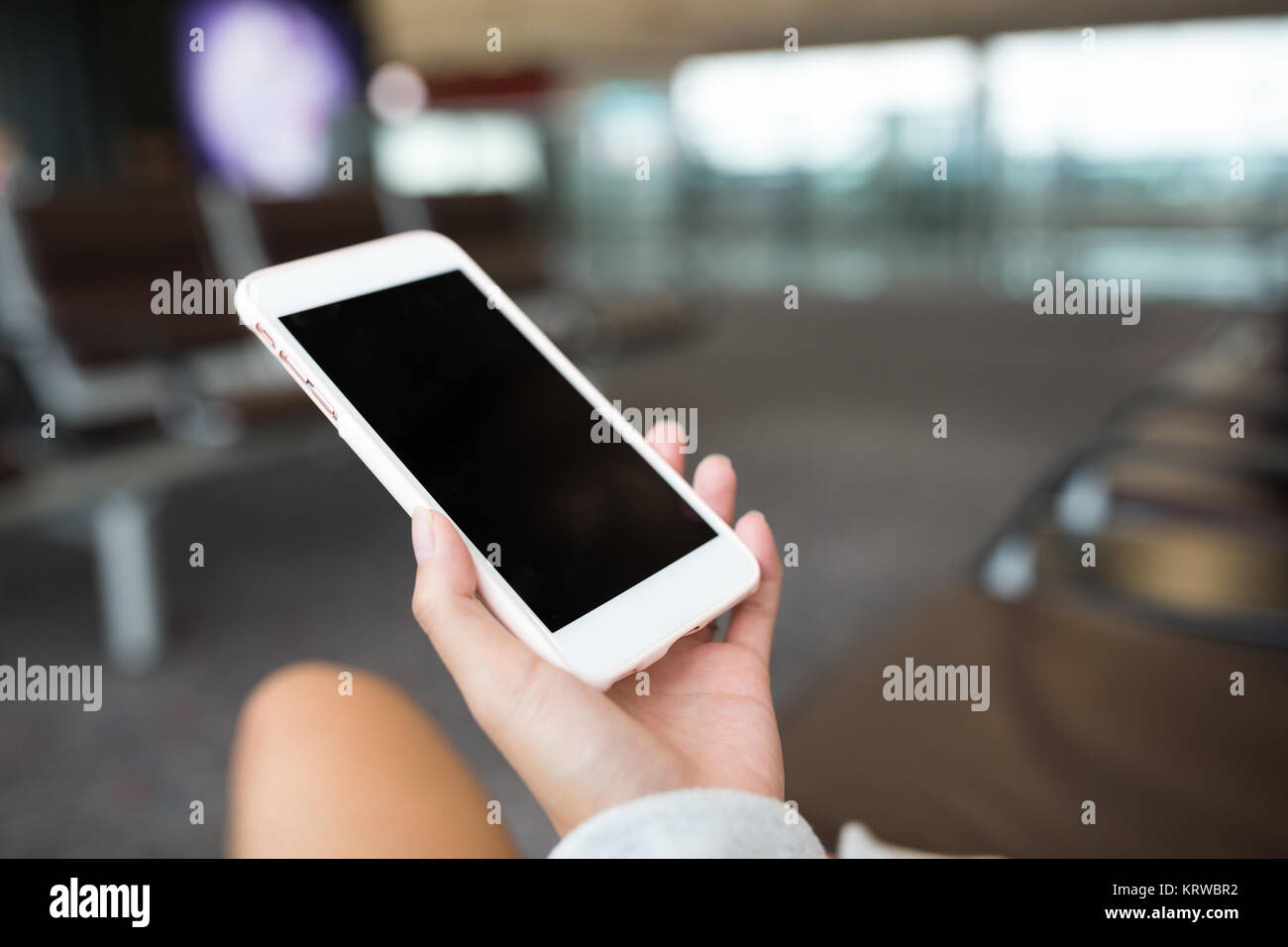 Woman using cellphone in airport Stock Photo - Alamy