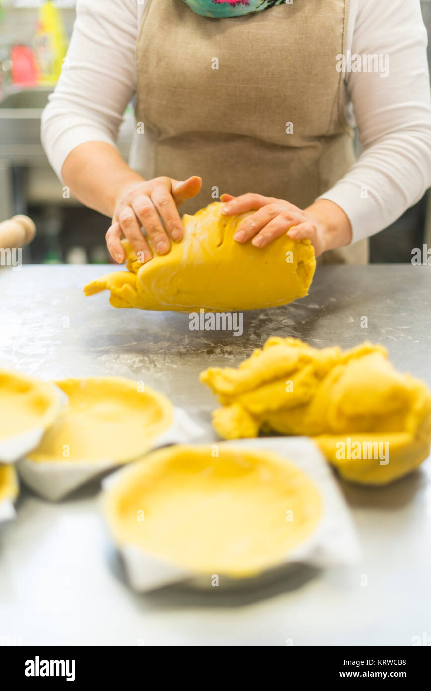 Chef pastry baker woman preparing and working out the dought made with ...