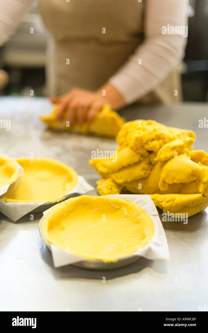 Chef pastry baker woman preparing and working out the dought made with ...