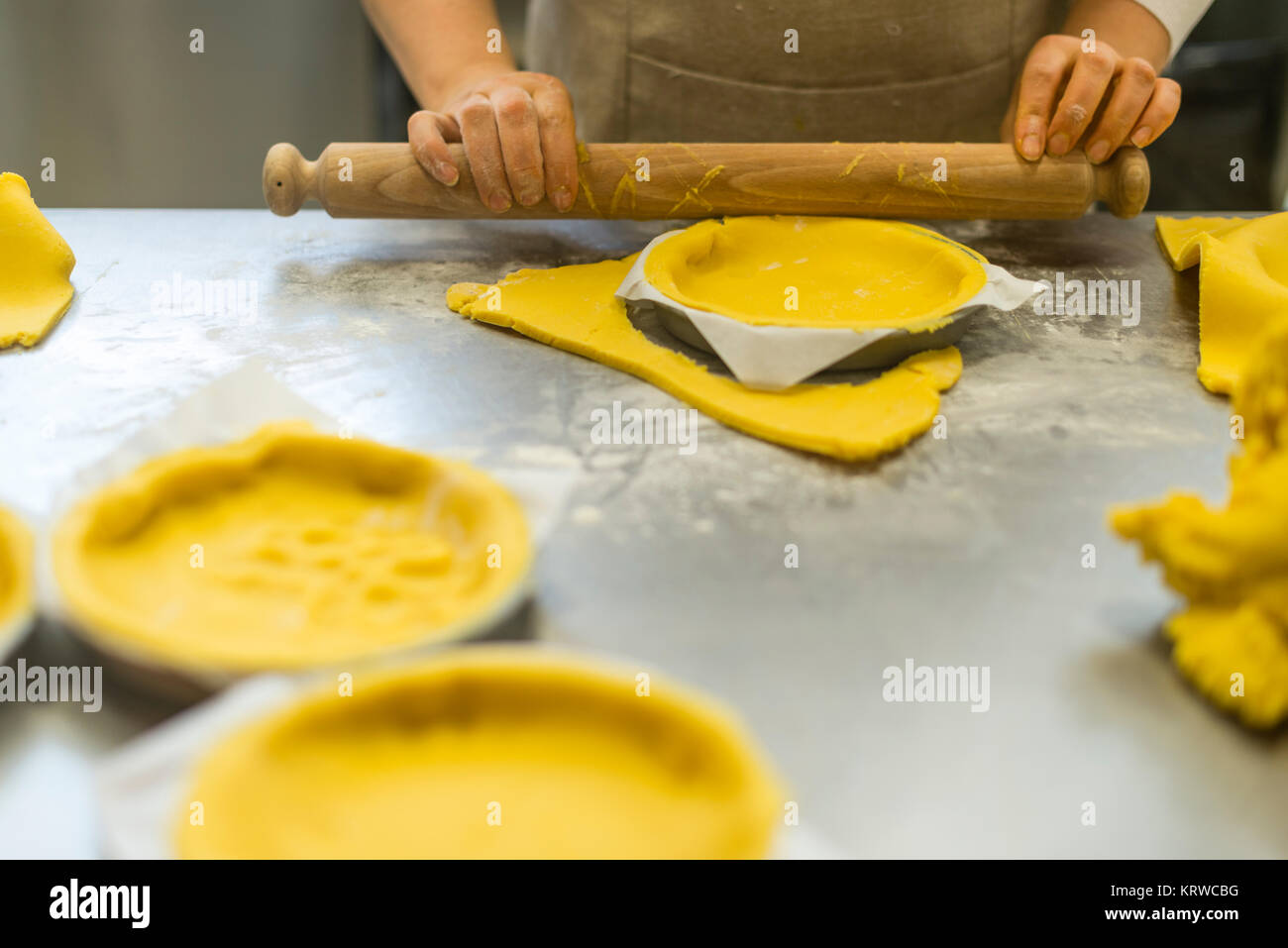 Chef pastry baker woman preparing and working out the dought made with ...