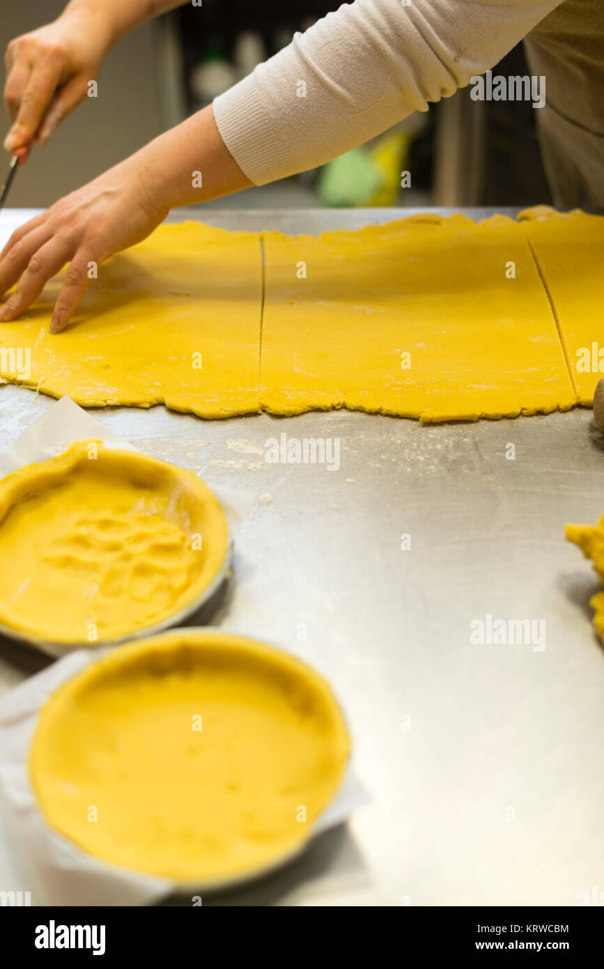 Chef pastry baker woman preparing and working out the dought made with ...