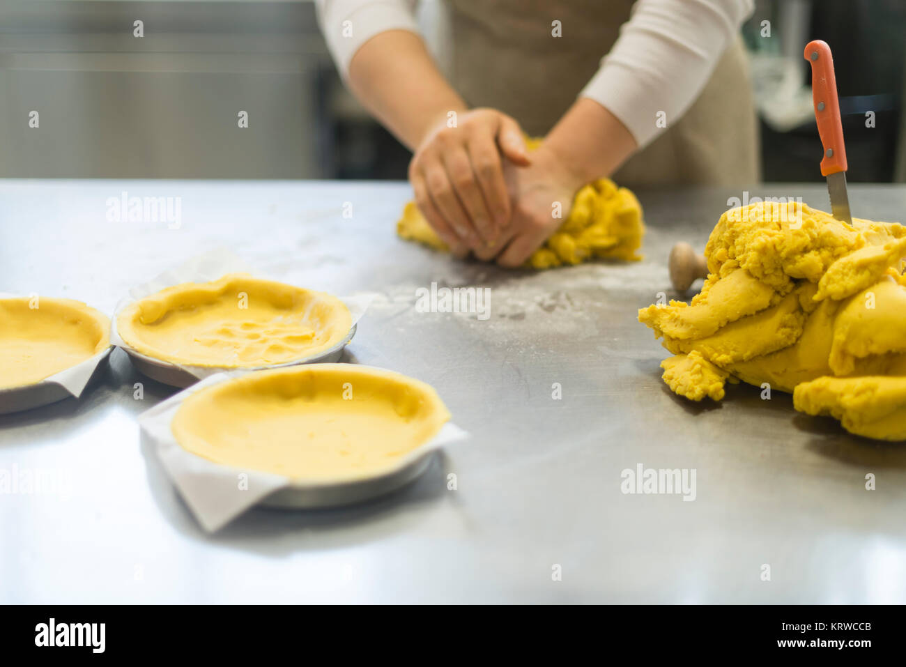 Chef pastry baker woman preparing and working out the dought made with ...