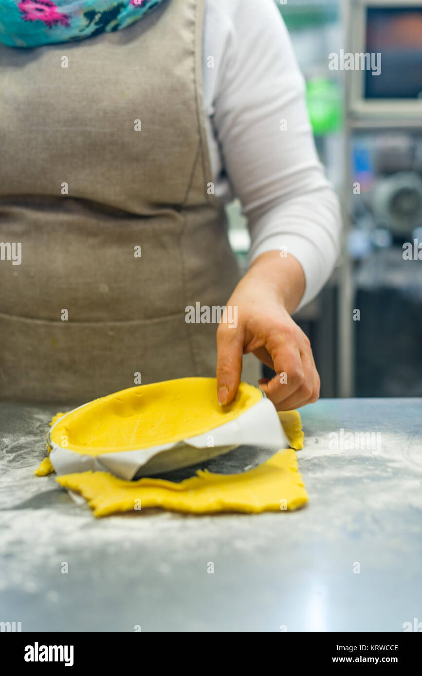 Chef pastry baker woman preparing and working out the dought made with ...