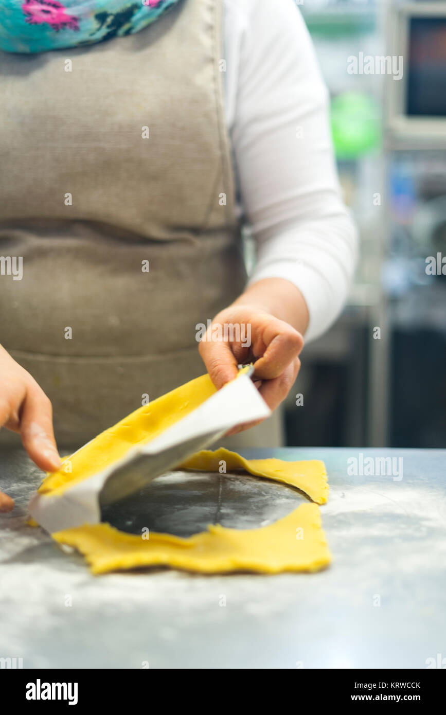 Chef pastry baker woman preparing and working out the dought made with ...