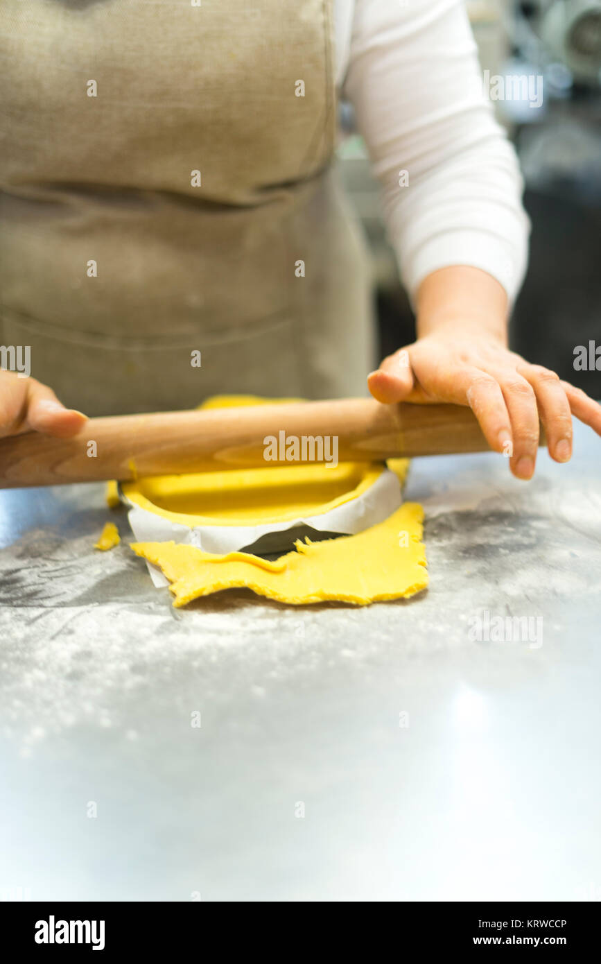 Chef pastry baker woman preparing and working out the dought made with ...