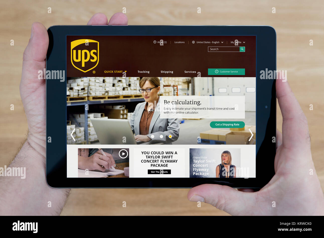 A man looks at the UPS website on his iPad tablet device, shot against ...