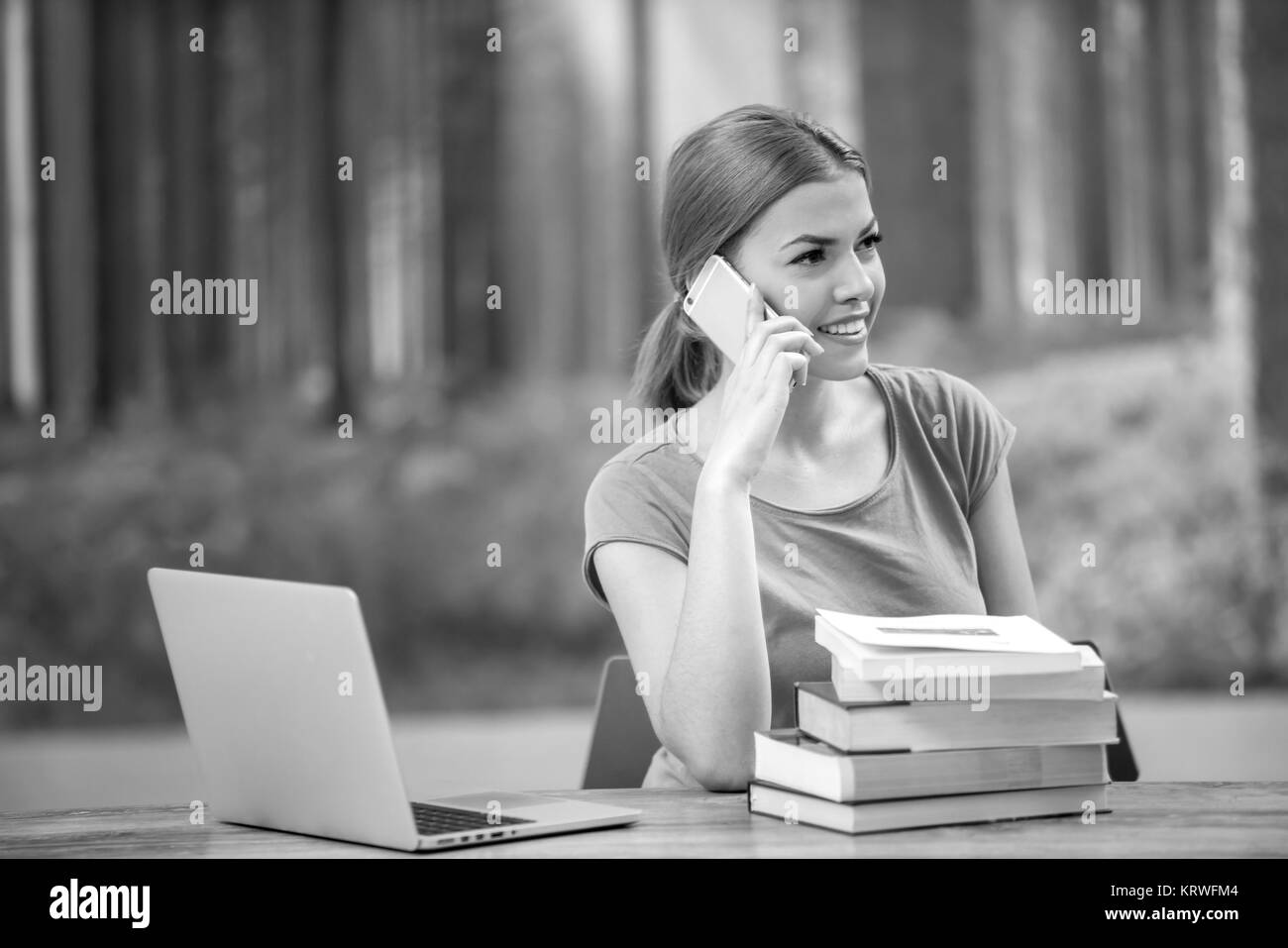 Young woman using laptop computer and smart phone. Beautiful student ...