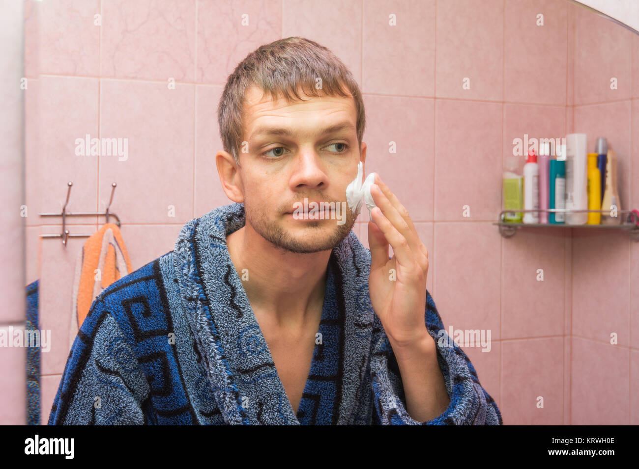 The young man begins to apply shaving foam on face Stock Photo - Alamy