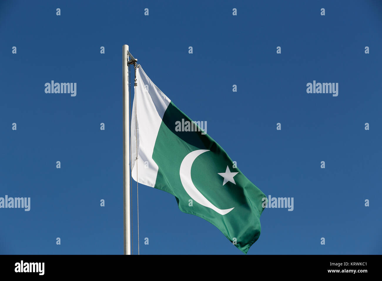 National flag of Pakistan on a flagpole in front of blue sky Stock ...