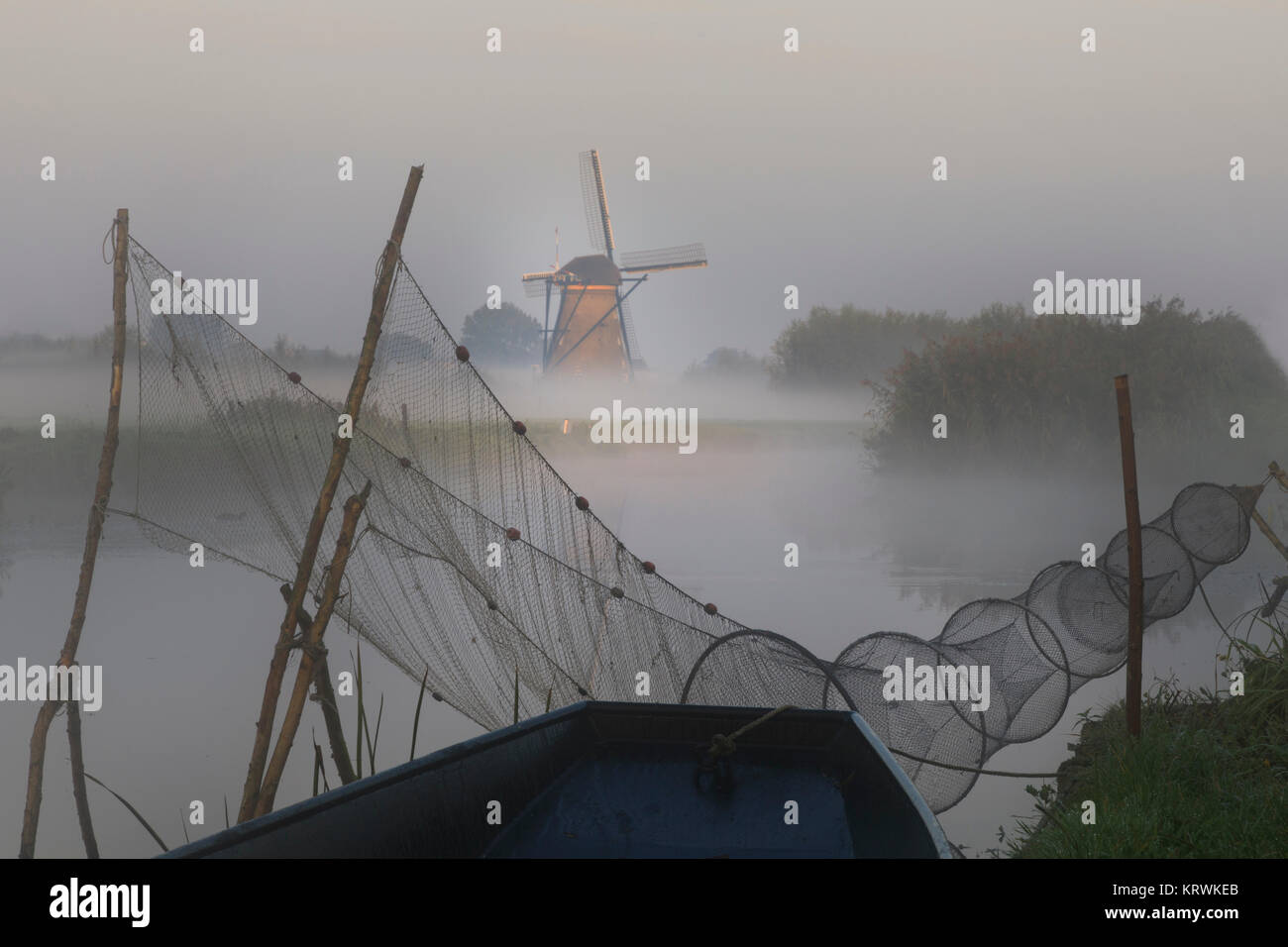 Fish trap in front of historical windmill in early mist, UNESCO World ...