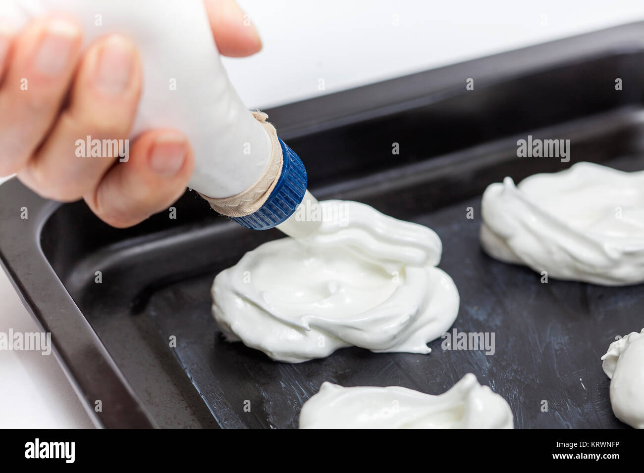 Meringues preparation : placing and shaping meringues on a baking sheet ...
