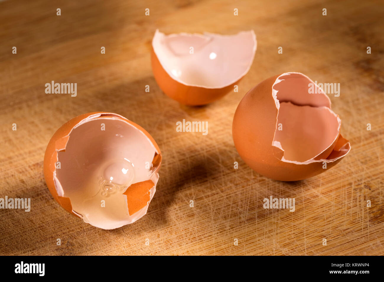 Close up of empty egg shells on wooden cutting board Stock Photo - Alamy