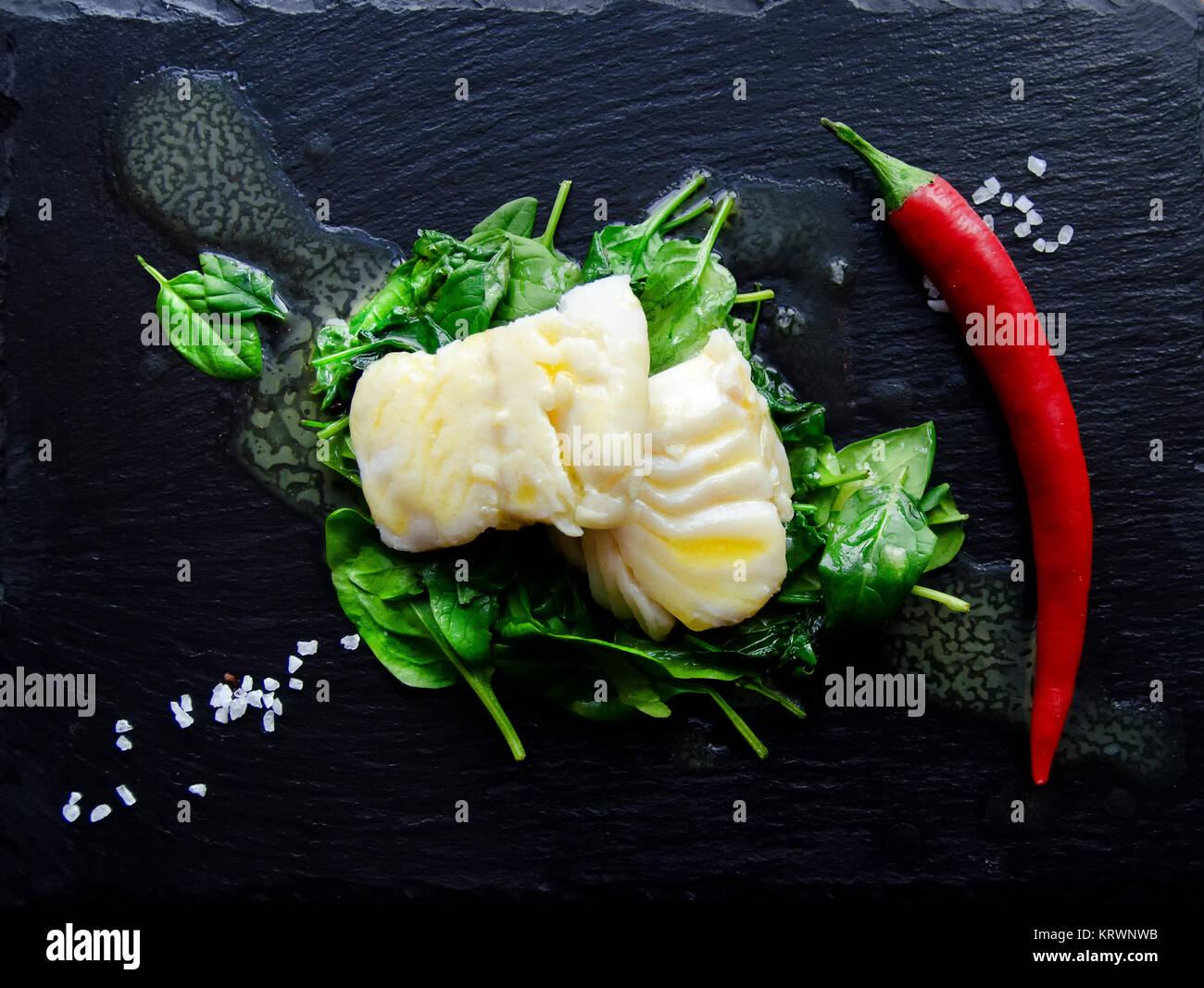 Fish fillet with chili on black background Stock Photo - Alamy