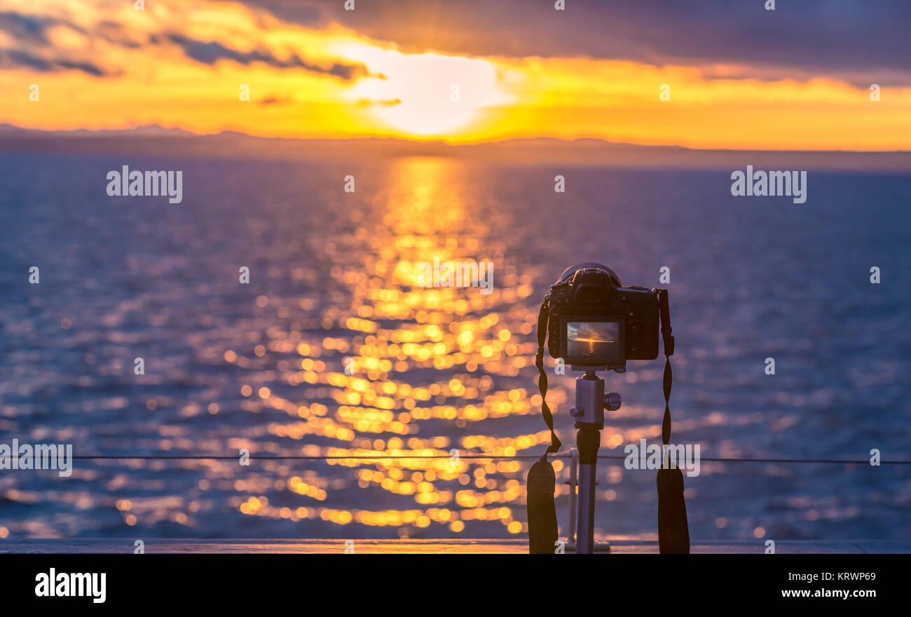 Sunset over water and a DSLR camera Stock Photo - Alamy