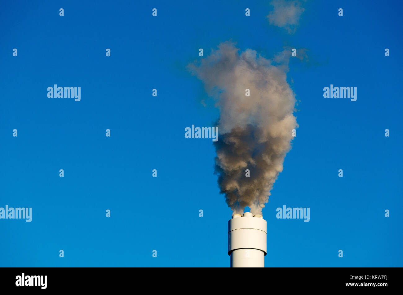 polluted smoke against a clear blue sky from the tall chimney Stock ...