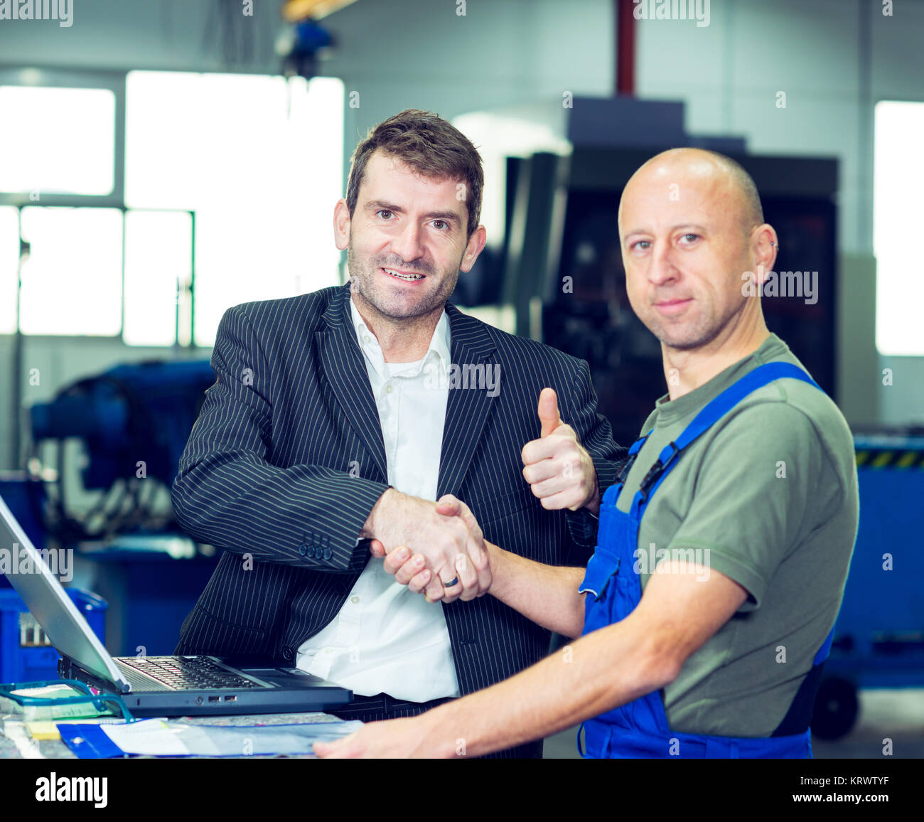 in the factory- young boss and worker with thumb up Stock Photo - Alamy