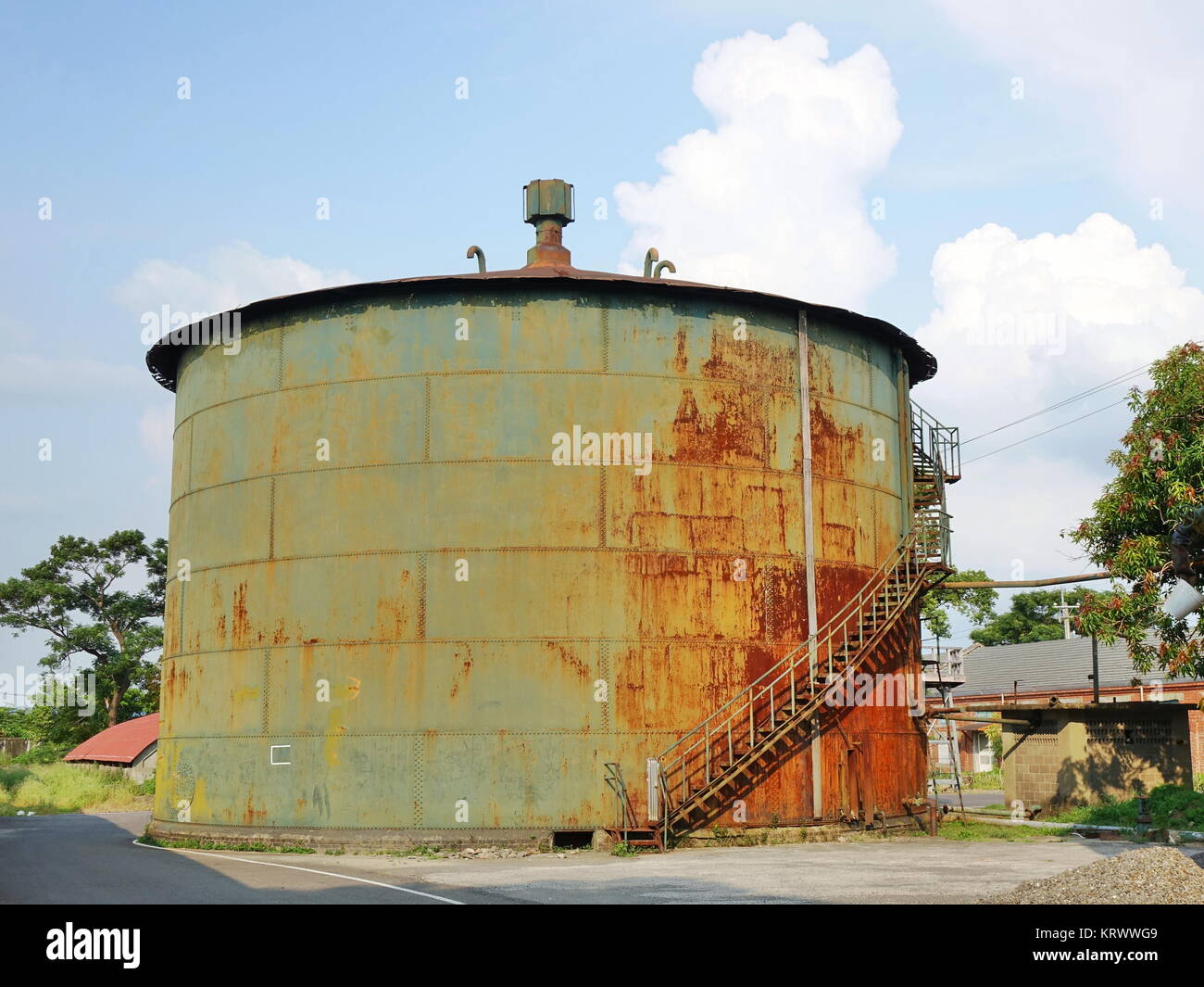 A large rusting storage tank at a vintage industrial facility Stock ...
