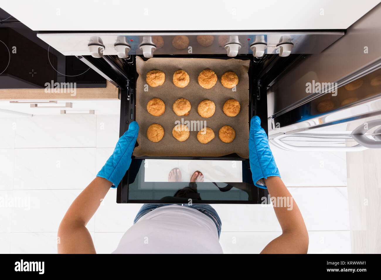 Woman Baking Cookies In Oven Stock Photo - Alamy