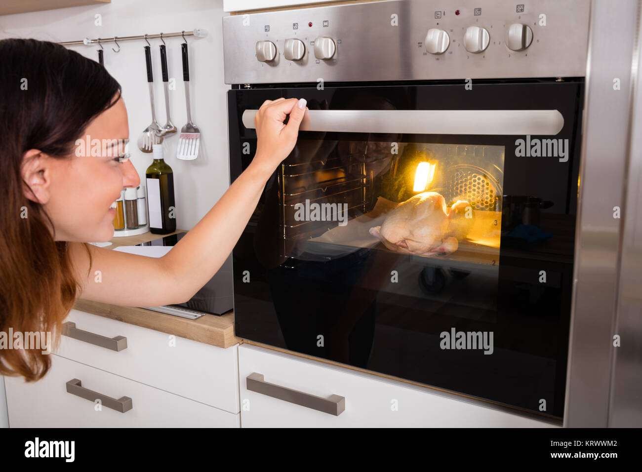 Woman Roasting Chicken Meat In Oven Stock Photo - Alamy