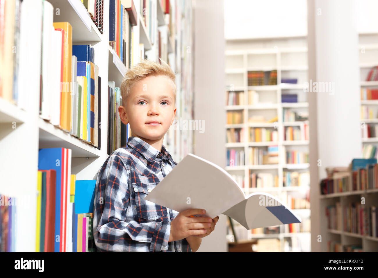 the child is reading a book. little student in the library Stock Photo ...