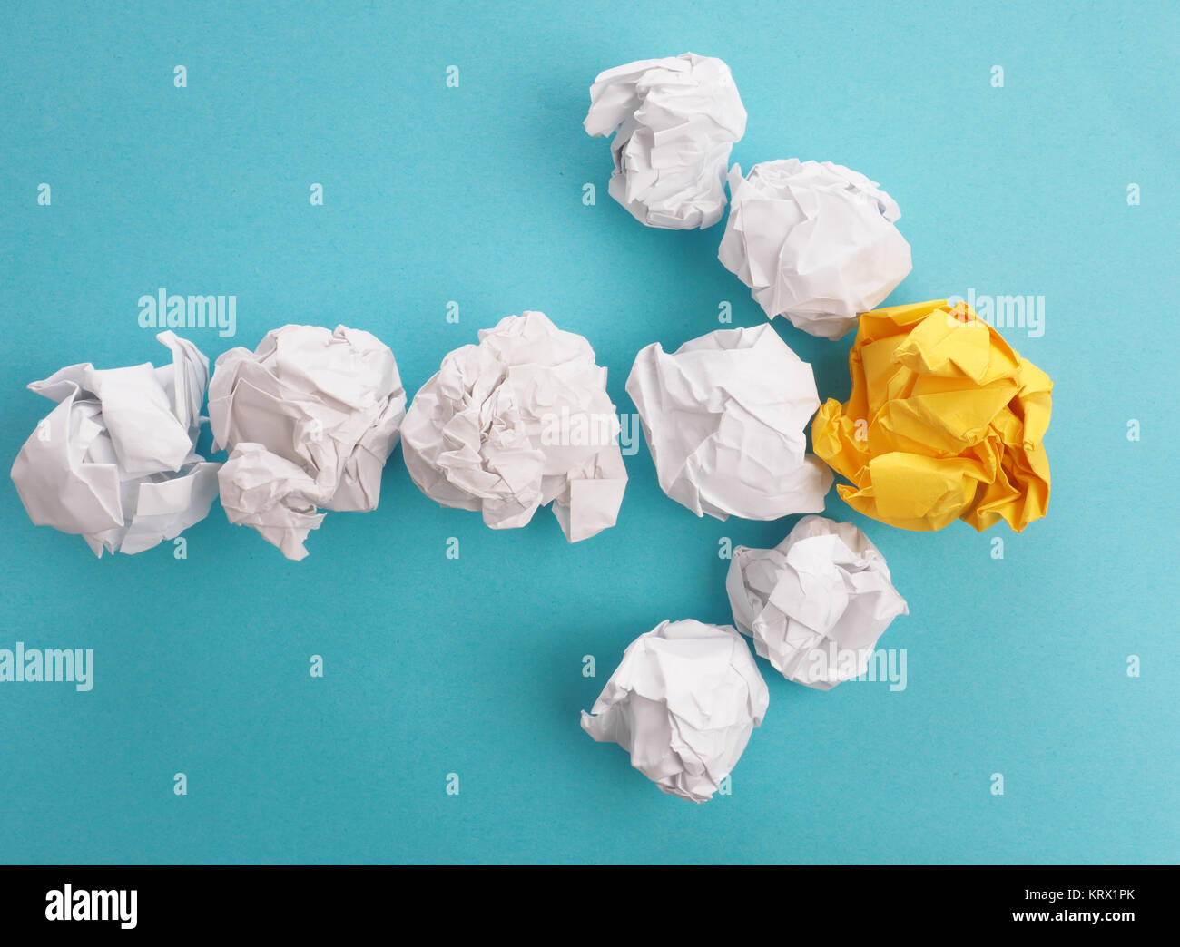 An arrow of crumpled paper on a blue background Stock Photo - Alamy