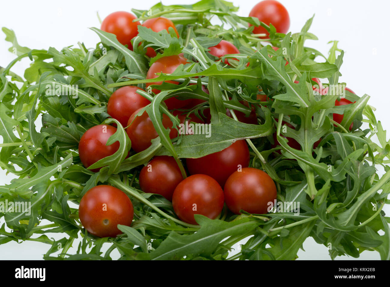 Heap of ruccola leaves and cherry tomatoes Stock Photo - Alamy