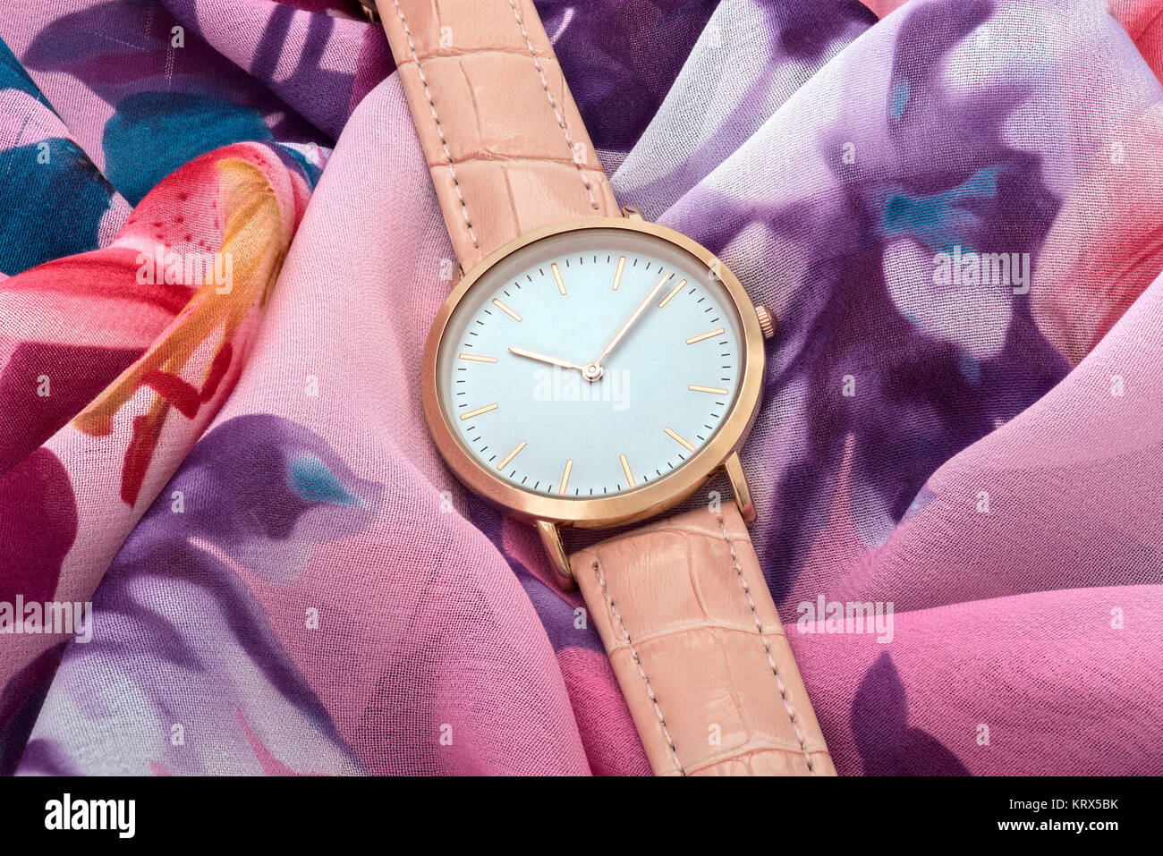 Pink wrist watch on colourful silk fabric background Stock Photo - Alamy
