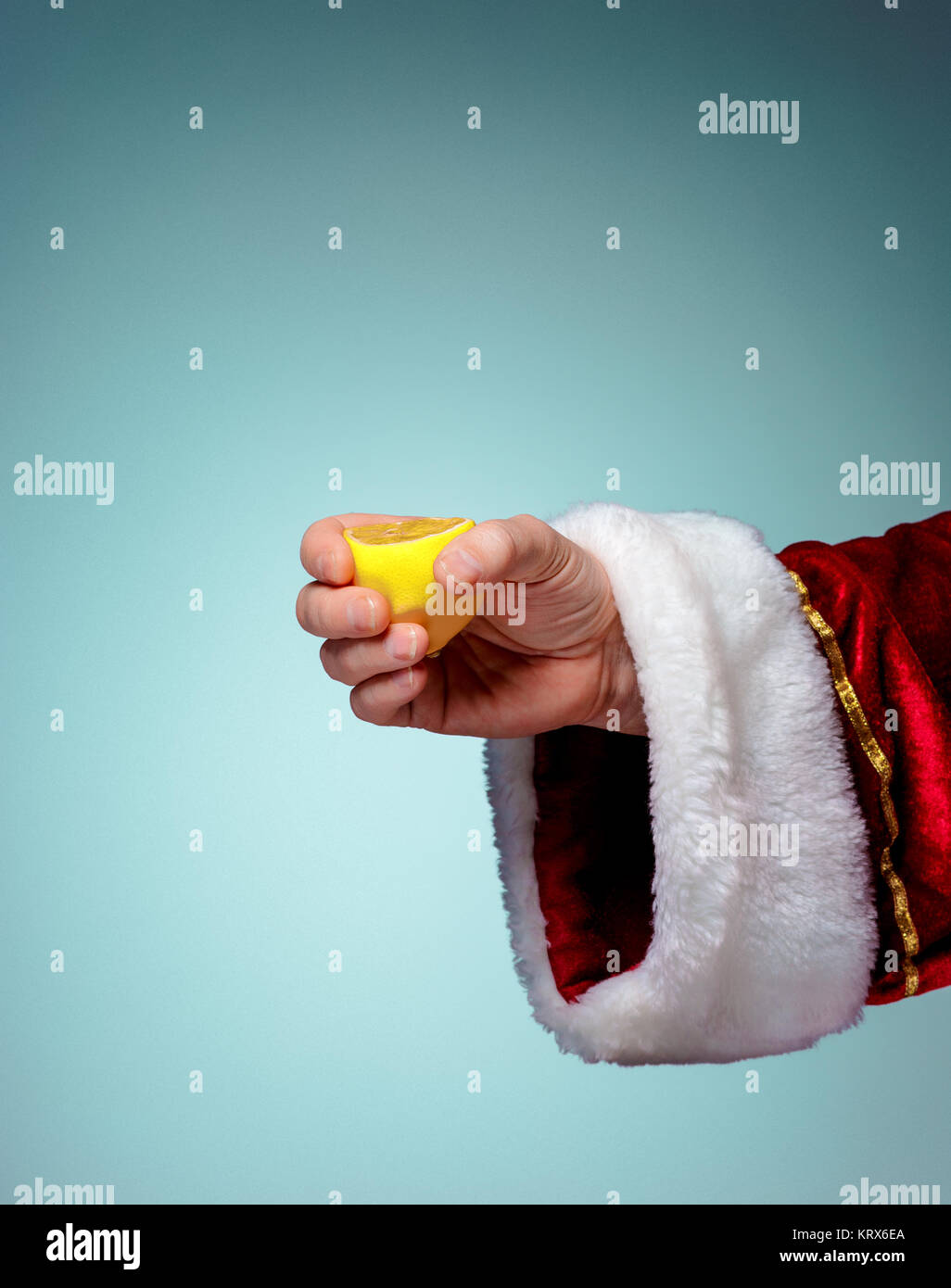 Photo of Santa Claus hand squeezing lemon Stock Photo - Alamy