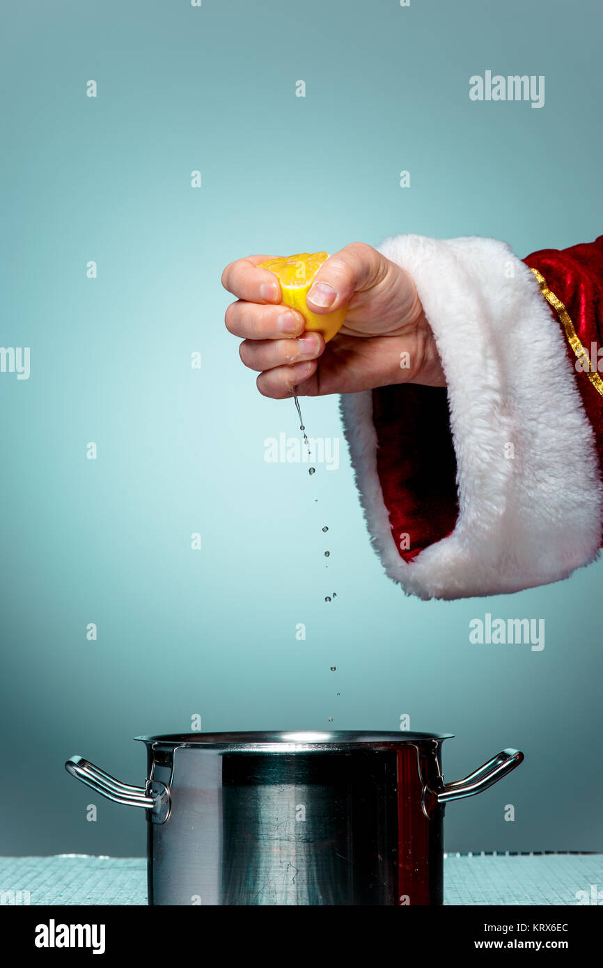 Photo of Santa Claus hand squeezing lemon Stock Photo - Alamy