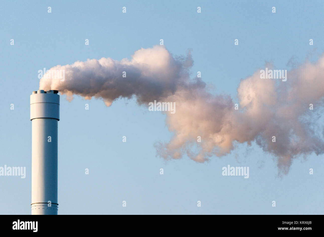polluted smoke against a clear blue sky from the tall chimney Stock ...