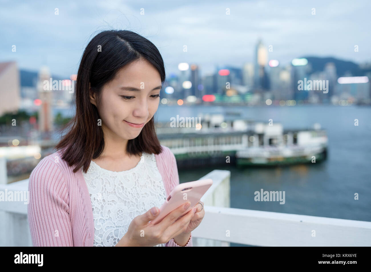 Woman texting ong cellphone in Hong Kong Stock Photo - Alamy