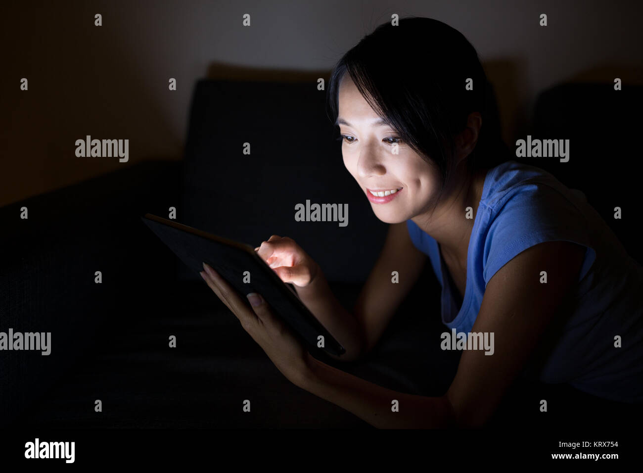 Woman using tablet computer at night Stock Photo - Alamy