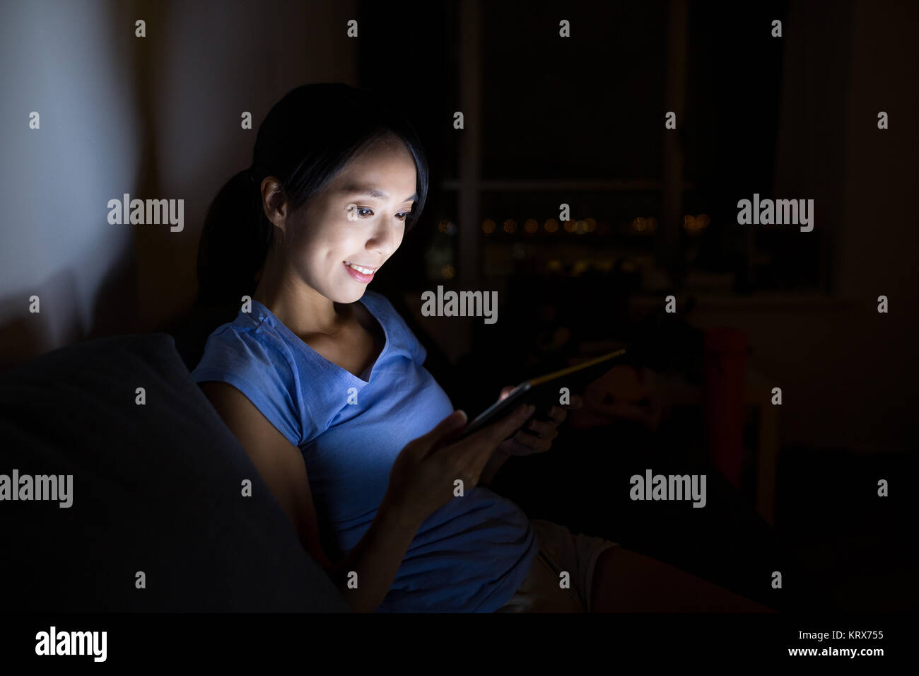 Woman using tablet at night Stock Photo - Alamy