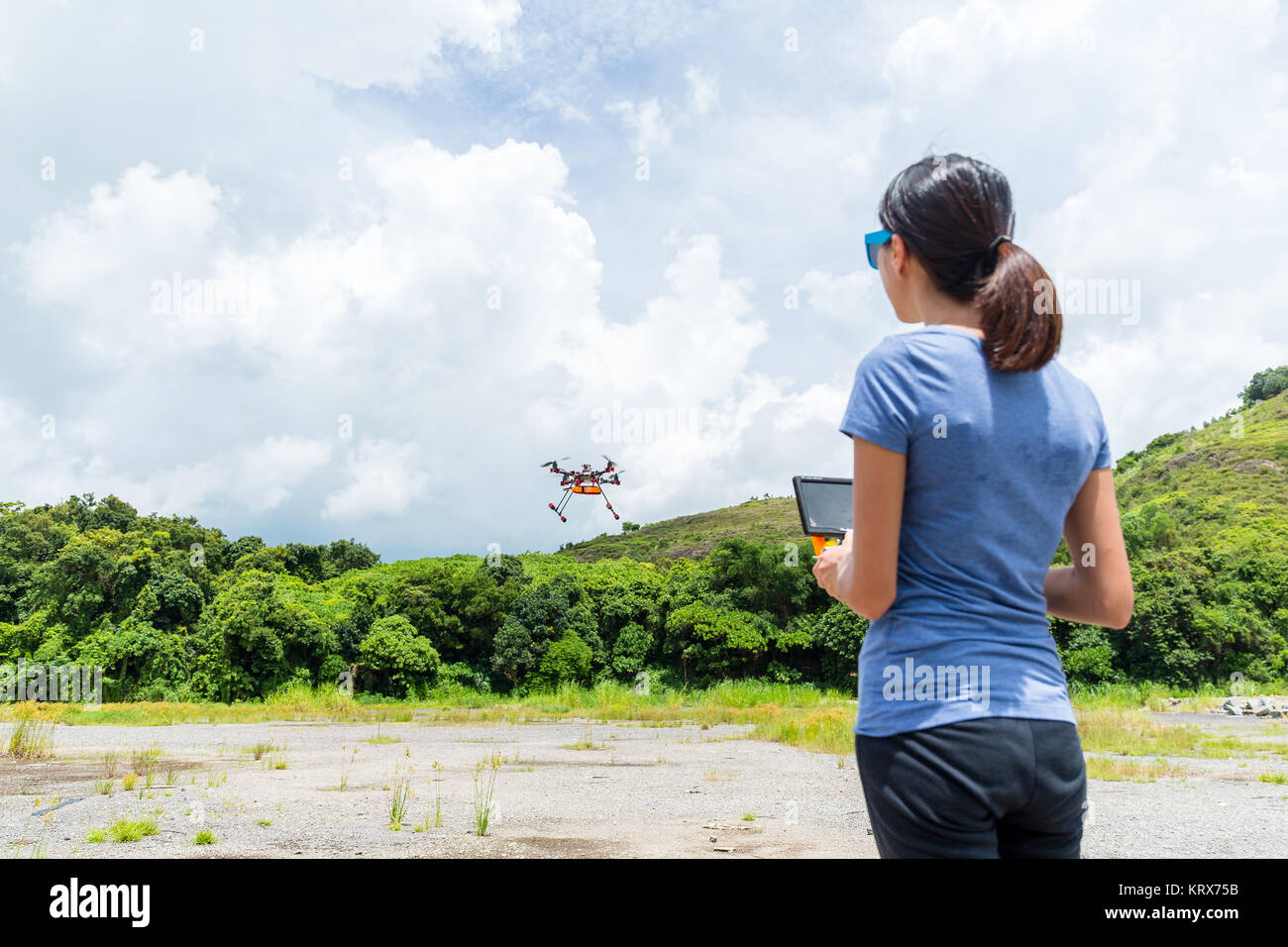 Woman control flying drone at outdoor Stock Photo - Alamy