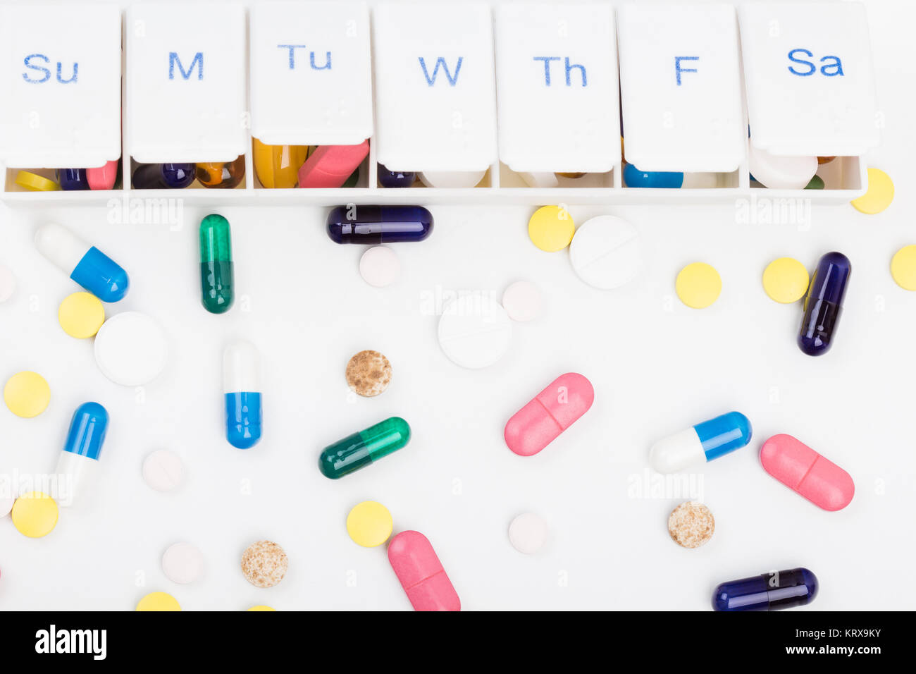 Color pills capsules and weekly pill organizer Stock Photo - Alamy