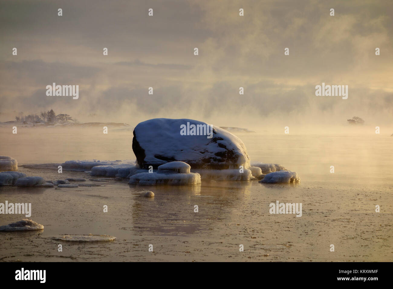 Ice covered rock in the sea that about to freeze over Stock Photo - Alamy