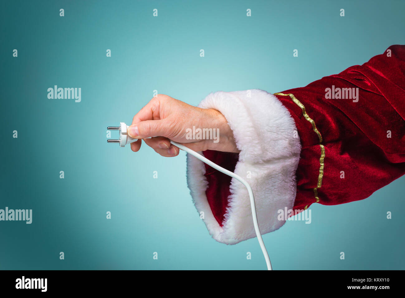 Hand of Santa Claus holding a electrical plug on blue background Stock ...